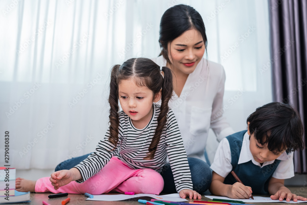 Mother teaching children in drawing class. Daughter and son painting ...