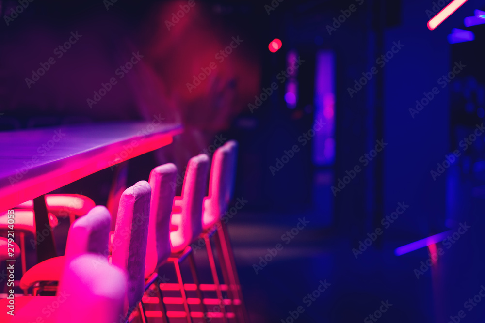 bar counter table in night club in neon blue and red lights. Party or ...
