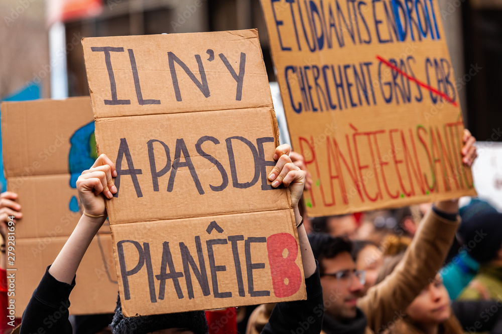 Ecological activists hold French signs. A cardboard sign with French ...