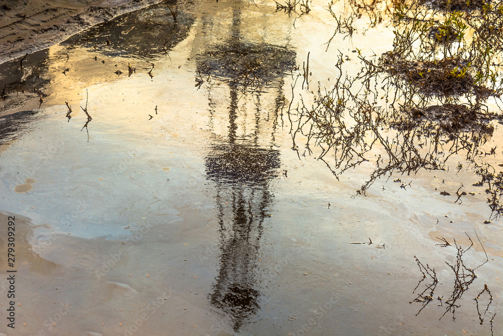 Reflection of blurred image of an oil rig in a puddle of oil. Dead ...