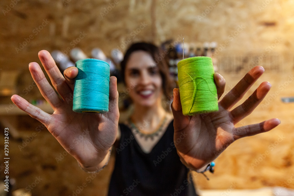 Fashion designer showing colorful thread. A local eco-designer is ...
