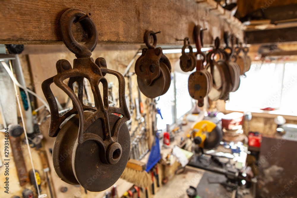 Rusty lifting wheels hanging in workshop. A closeup view on old rusted ...