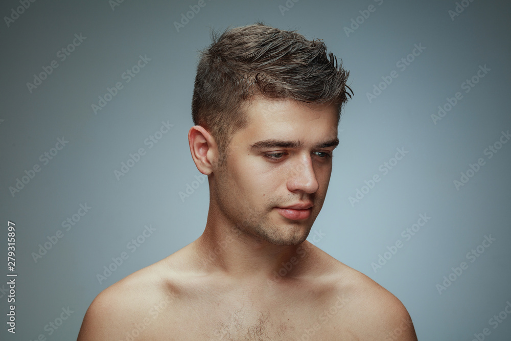 Portrait of shirtless young man isolated on grey studio background ...