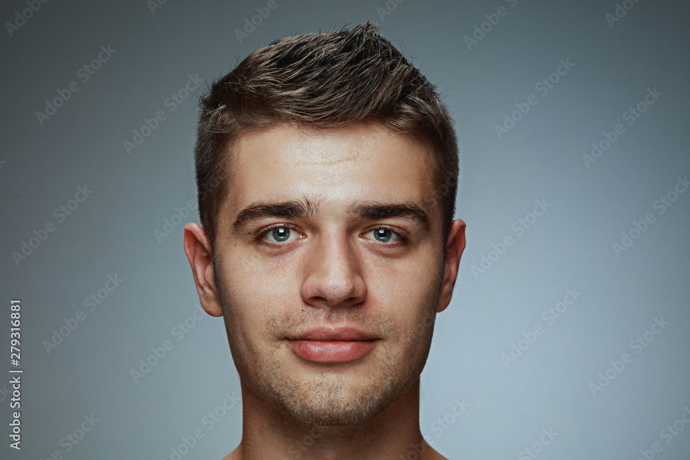 Portrait of shirtless young man isolated on grey studio background ...