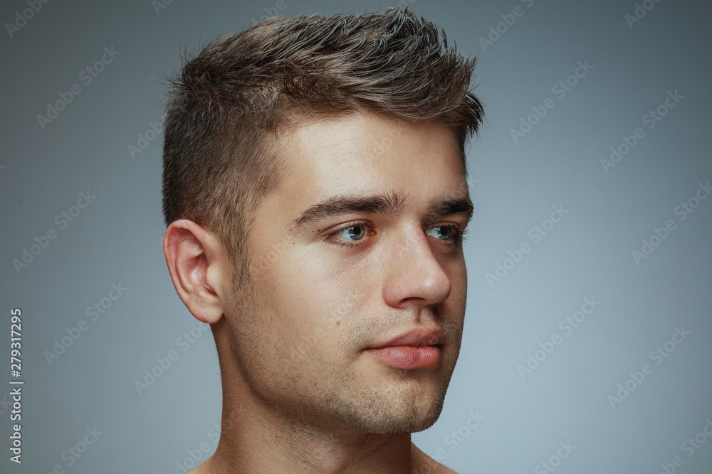 Portrait of shirtless young man isolated on grey studio background ...