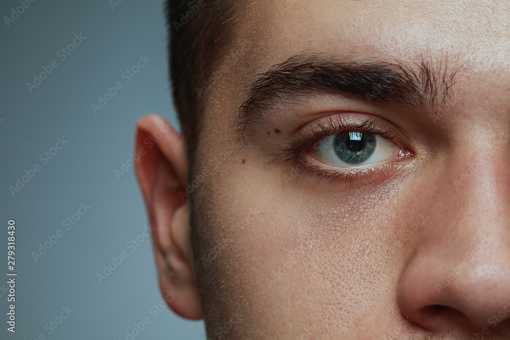 Close-up portrait of young man isolated on grey studio background ...