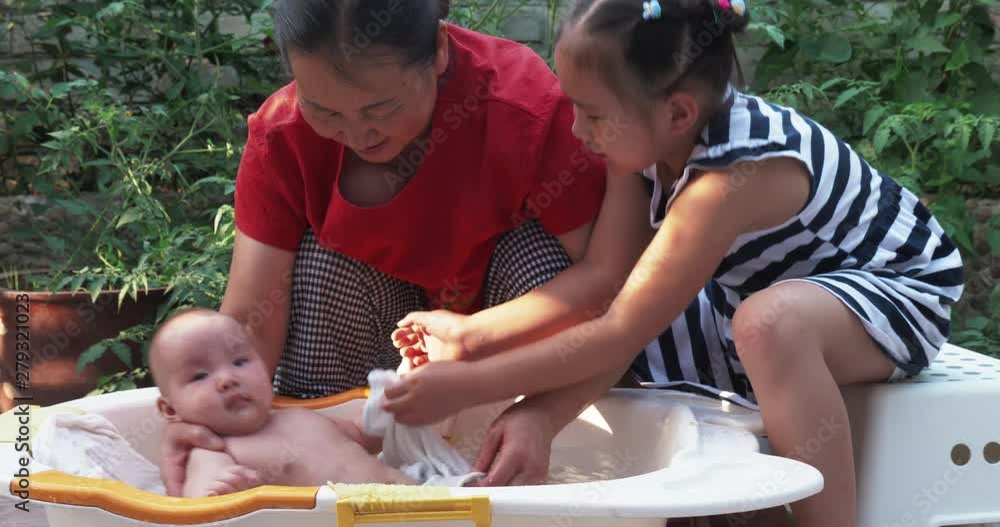 Newborn baby with family in the yard Chinese infant taking bath in the ...