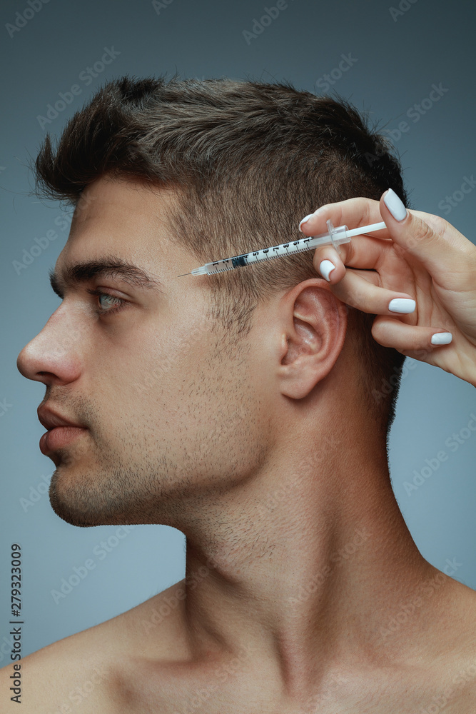 Close-up profile portrait of young man isolated on grey studio ...
