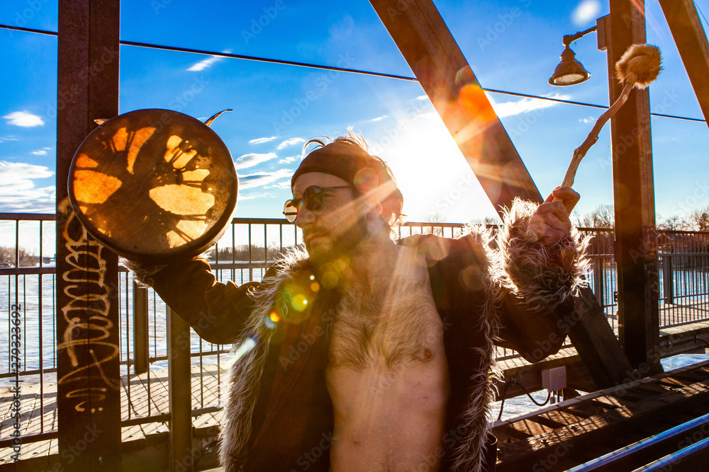 Medicine man stands on railway bridge. A backlit view of a spiritual ...