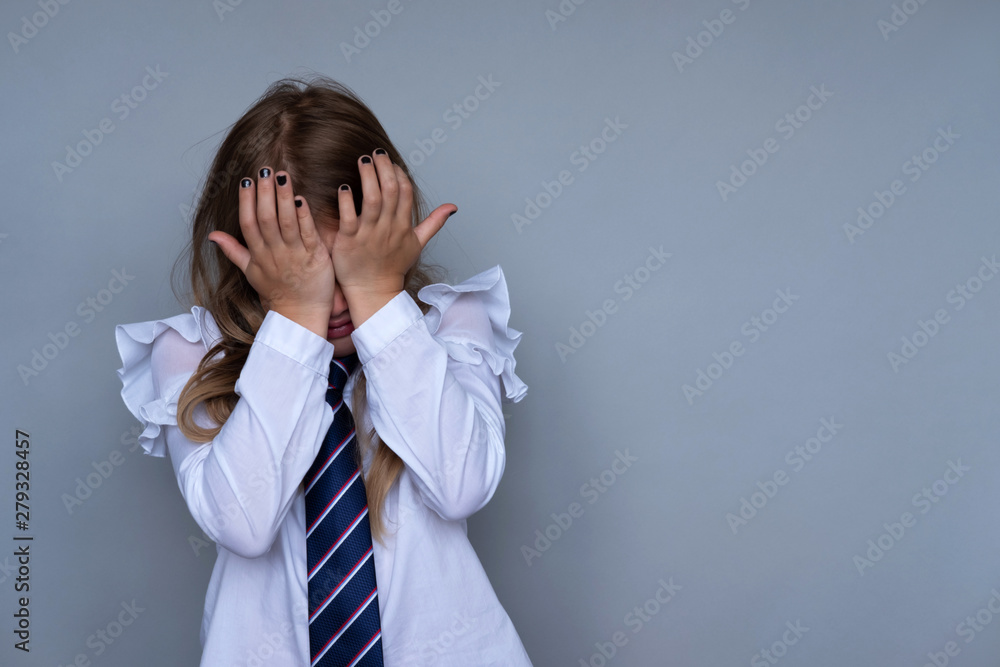 Small schoolgirl covering face, crying portrait. Preteen stressed ...