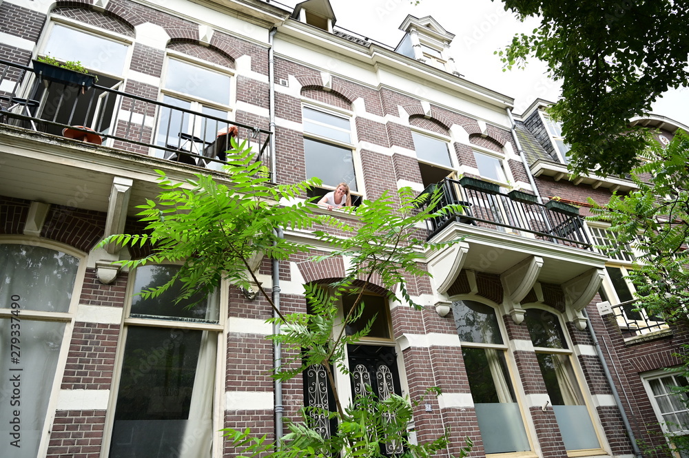 Dutch student girl leaning outside the front window of her student ...