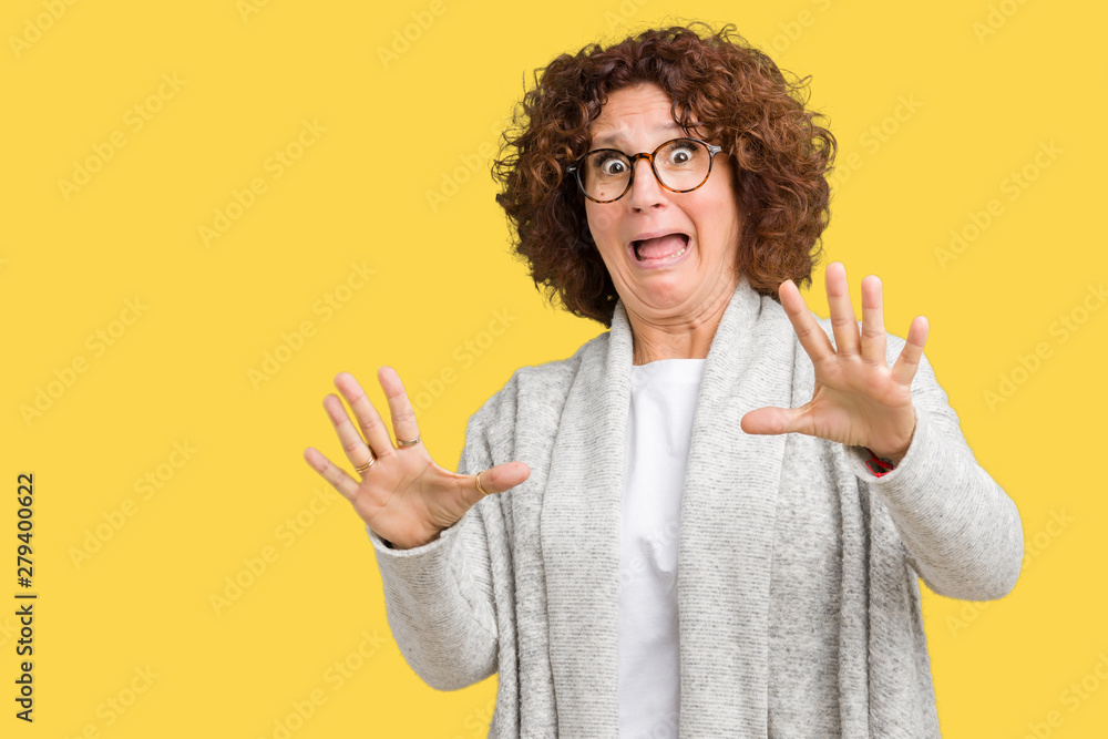 Beautiful middle ager senior woman wearing jacket and glasses over ...