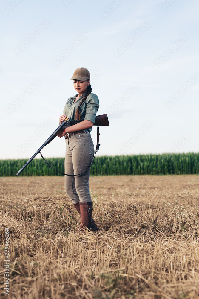 Attractive female hunter reloading her rifle. Stock Photo | Adobe Stock