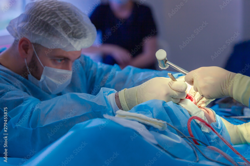 Surgeon and his assistant performing cosmetic surgery on nose in ...
