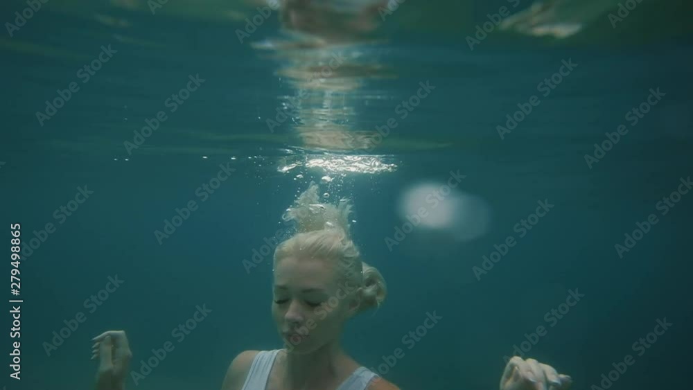 Beautiful blonde woman emerges from the water in the sea on travel ...