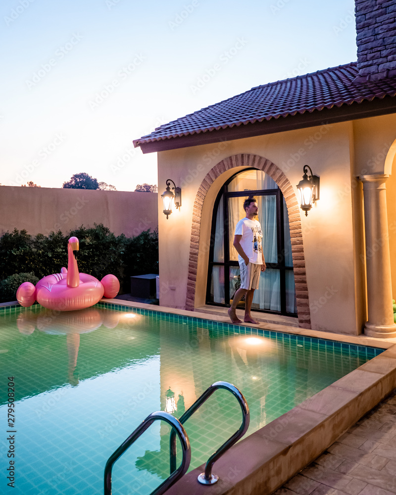 young men watching sunse tby the pool , swimming pool during sunset ...