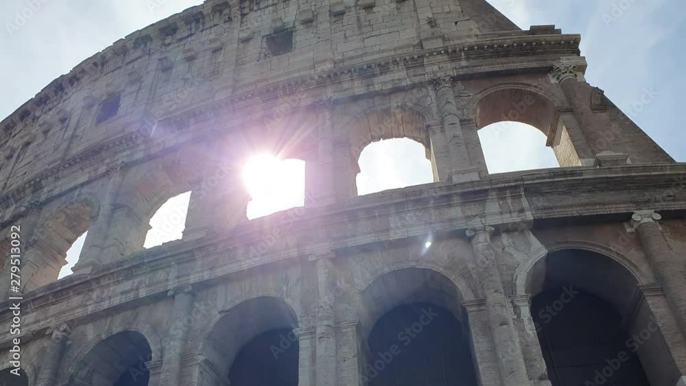 A ray of sun passes through the arches of the Colosseum in Rome, Italy ...