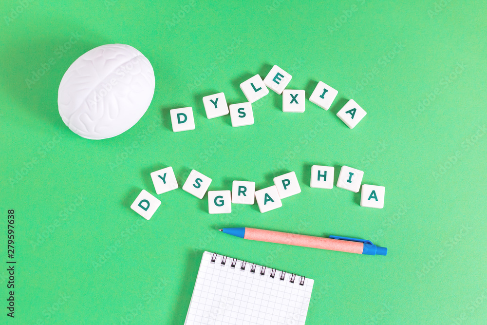 Dyslexia and dysgraphia words with an open notebook and pen on green ...
