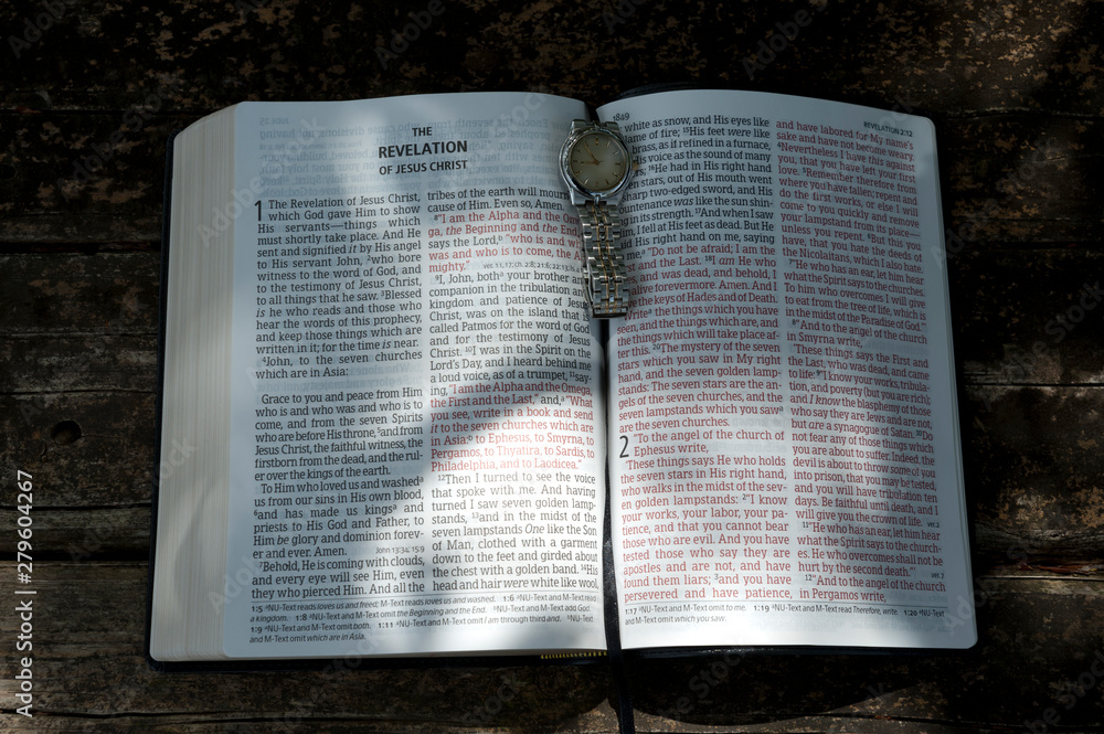 Clock on open Bible in Revelation of Jesus Christ in chapters 1 and 2 ...