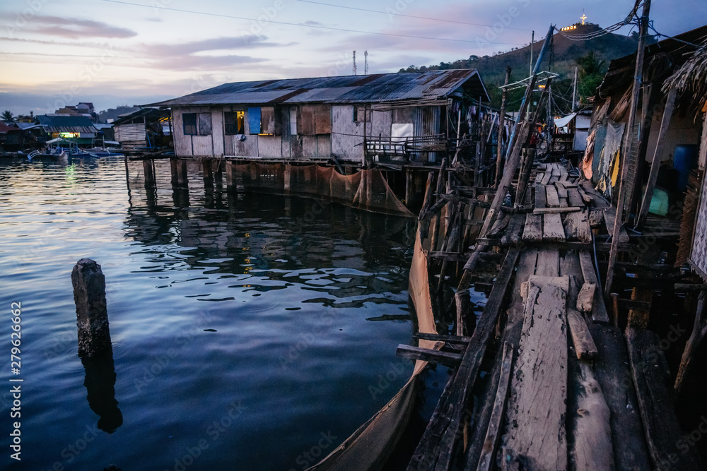Poor district slums with wooden houses near water at dusk, Coron city ...