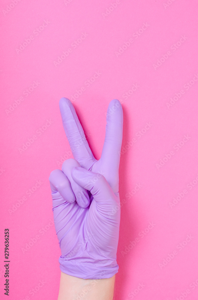 Human hand wearing purple, medical glove shows two fingers forming ...