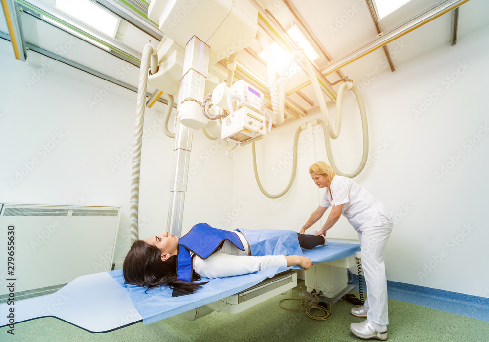 Radiologist and patient in a x-ray room. Classic ceiling-mounted x-ray ...