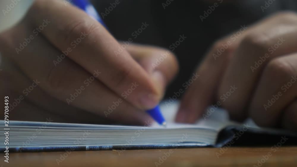 man writes in notebook. man's hand writing in a lifestyle notepad ...