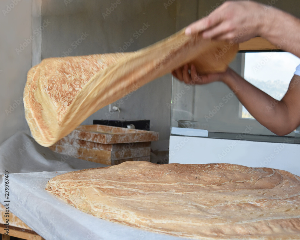 large thin sheets of lebanese bread called markook being set in a pile ...