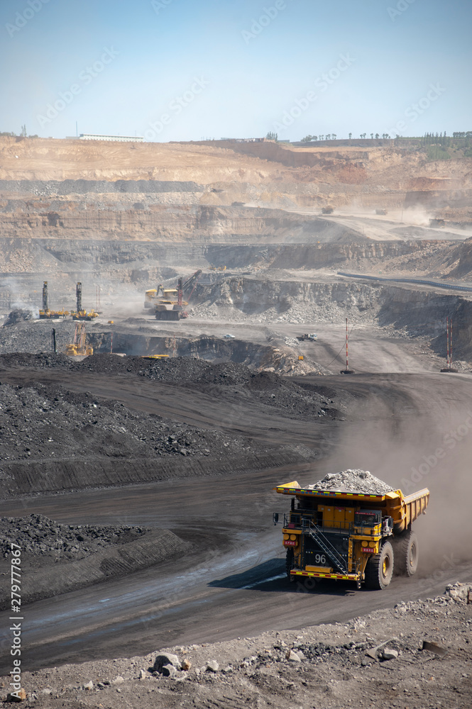 Big yellow mining truck hauling rock in dusty coal mine Stock Photo ...