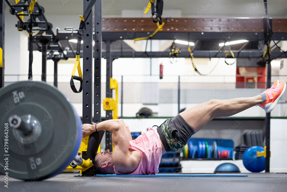 Strong man training his back in gym with dumbbells. Stock Photo | Adobe ...