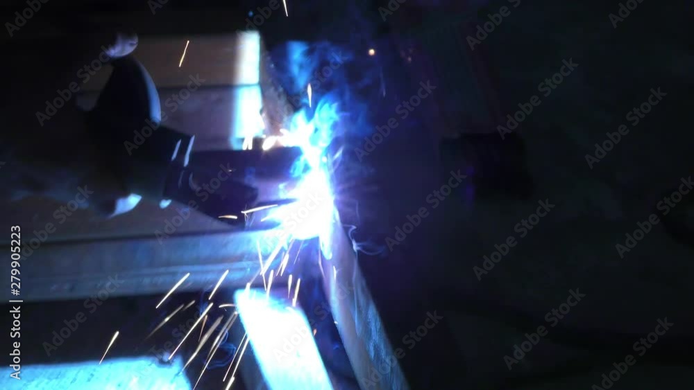 The sparklers and the flash of light when welding the joints of iron ...
