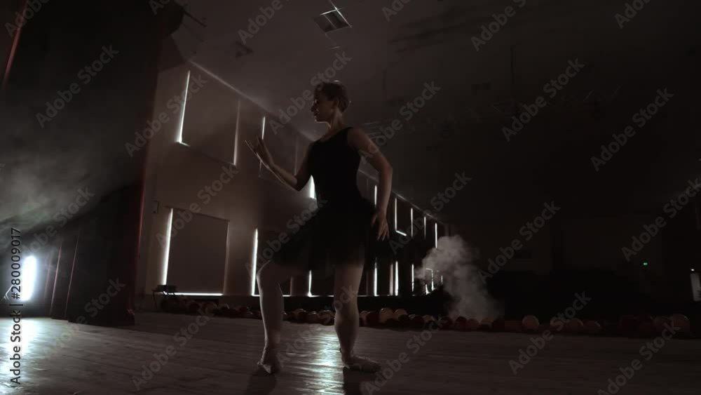A slowly dancing ballerina in front of spot lights. Several spotlights ...