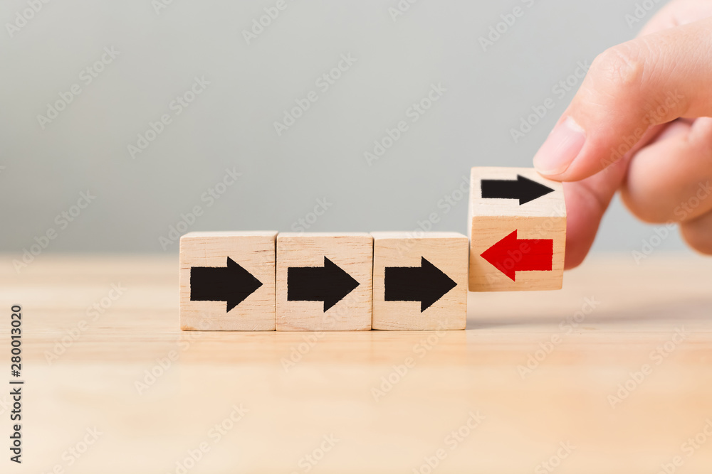 Hand flip over wooden cube block with red arrow facing the opposite ...
