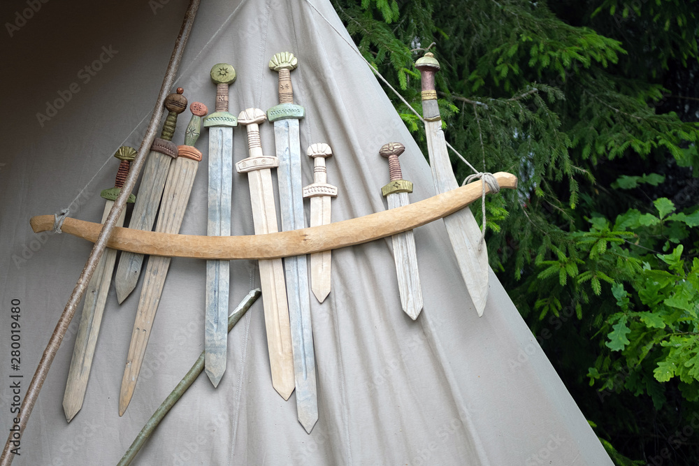 Wooden medieval weapons replicas for close combat displayed on grey ...