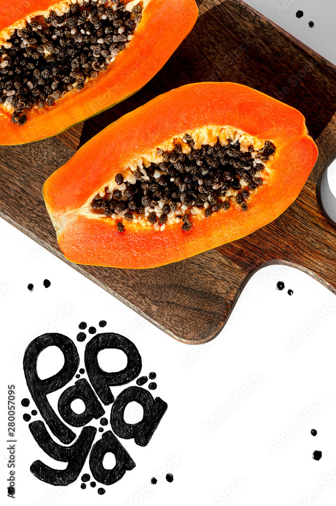 Flat lay of papaya exotic tropical fruit and hand lettering with pencil ...