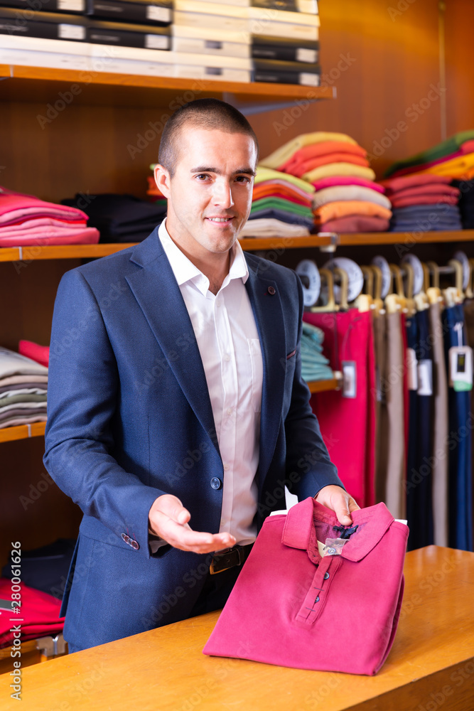 Polite salesman offering stylish polo shirt Stock Photo | Adobe Stock