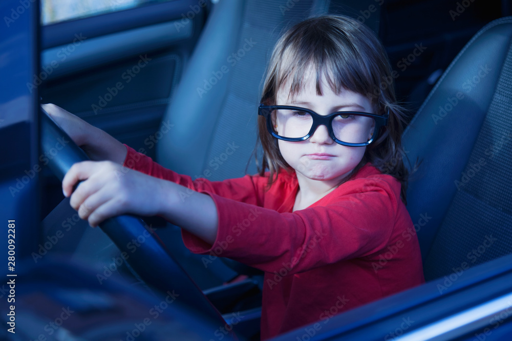 Dangers and risks of underage driving. Humorous photo of upset little ...