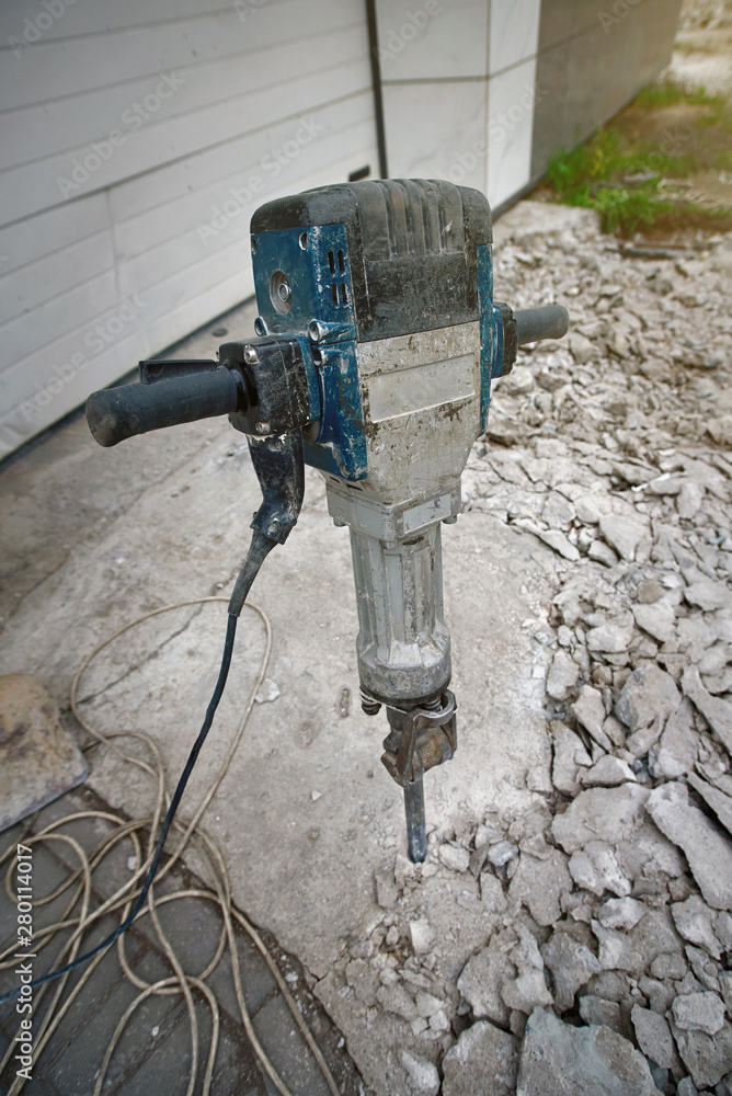 Removing concrete floor with jackhammer tool. Concrete rubble debris on ...