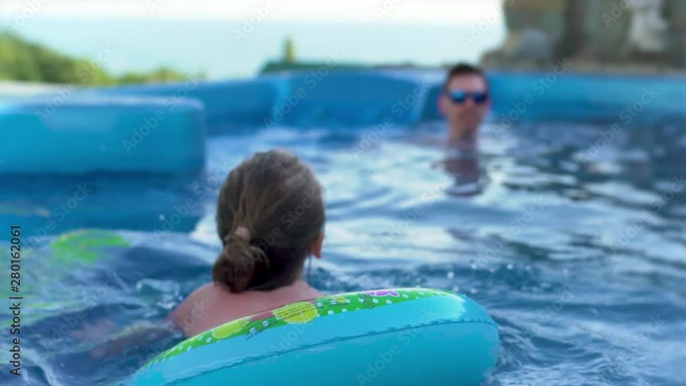 Child and vacation father in swimming pool in summer, close-up of kid ...
