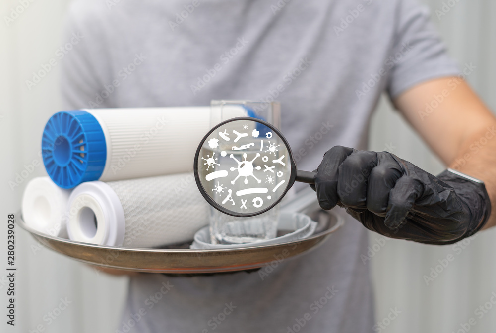 Service man hold water filtering cartridges with glass and spanner ...
