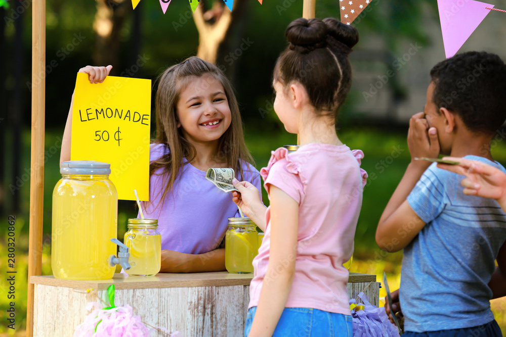Little girl selling natural lemonade to kids in park. Summer refreshing ...