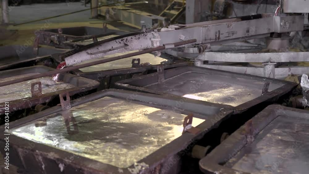 Close-up, the hot metal is poured from the furnaces special baths ...