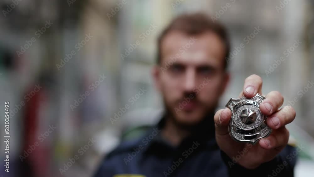 Close-up blurred american policeman holding a police badge on camera ...