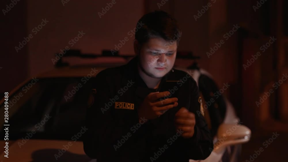 Portrait handsome young police officer chatting in social network on ...