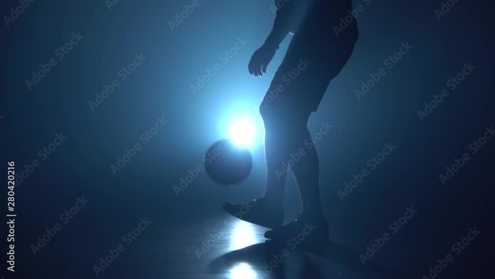 Slow motion of football player's feet stuffing ball in twilight. Stock ...