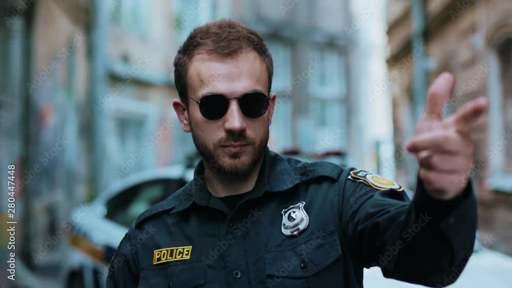 Face smiling young man with sunglasses cops stand near patrol car look ...