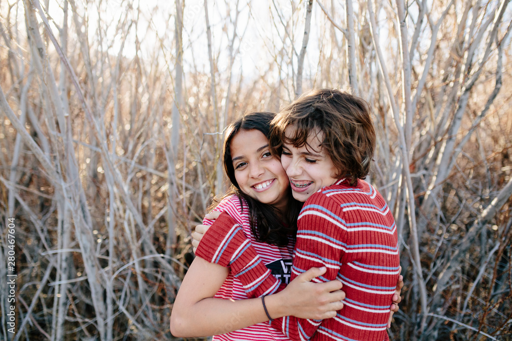 Young teen sisters hug cheek to cheek and smile in a wooded area Stock ...