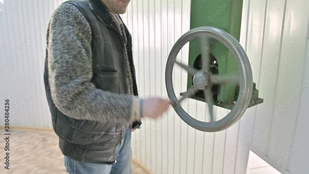A male researcher rotates the manual wheel of the opening mechanism of ...