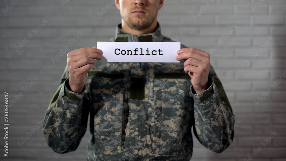 Conflict word written on sign in hands of soldier, military annexation ...