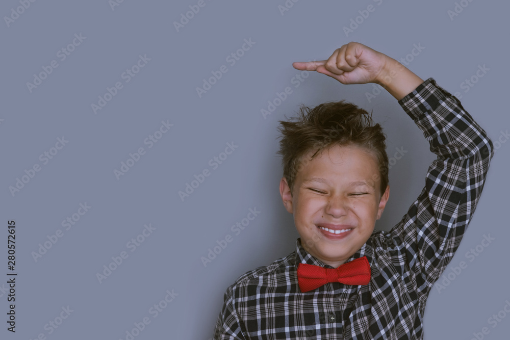 Young schoolchild pointing up portrait. Preteen schoolboy with glasses ...